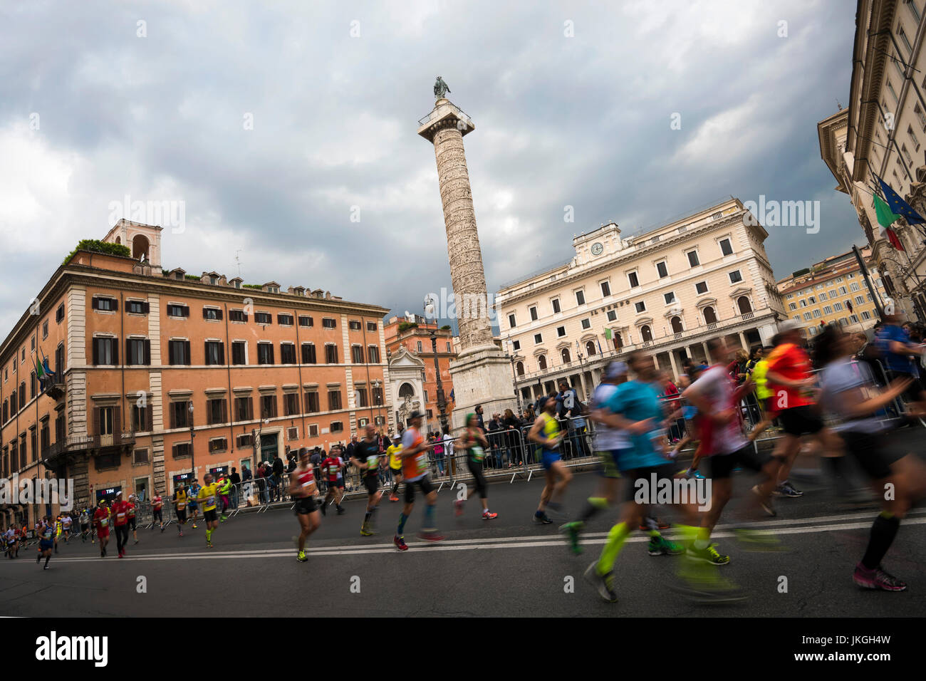 Horizontal view of marathon runners going passed Piazza Colonna in Rome ...