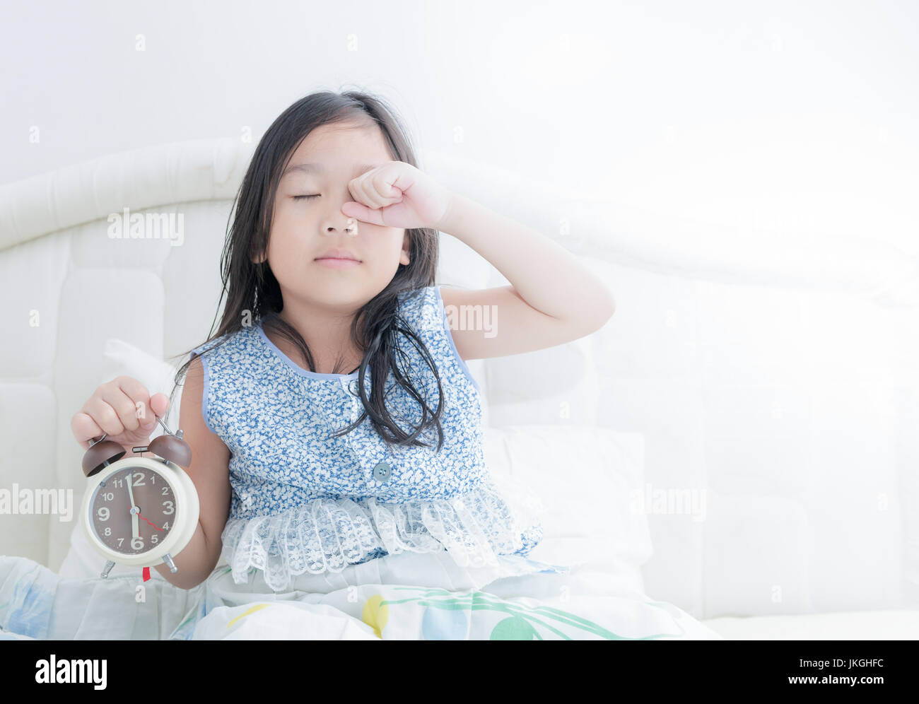 cute girl wakes up in the morning with alarm clock in the bedroom Stock ...