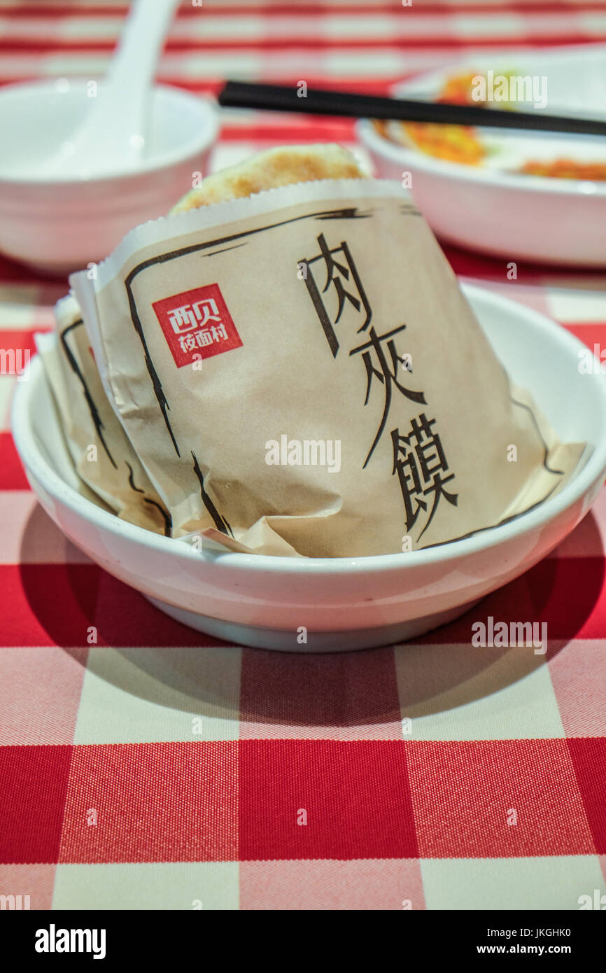 Two Chinese meat buns in a plate on a dining table Stock Photo - Alamy