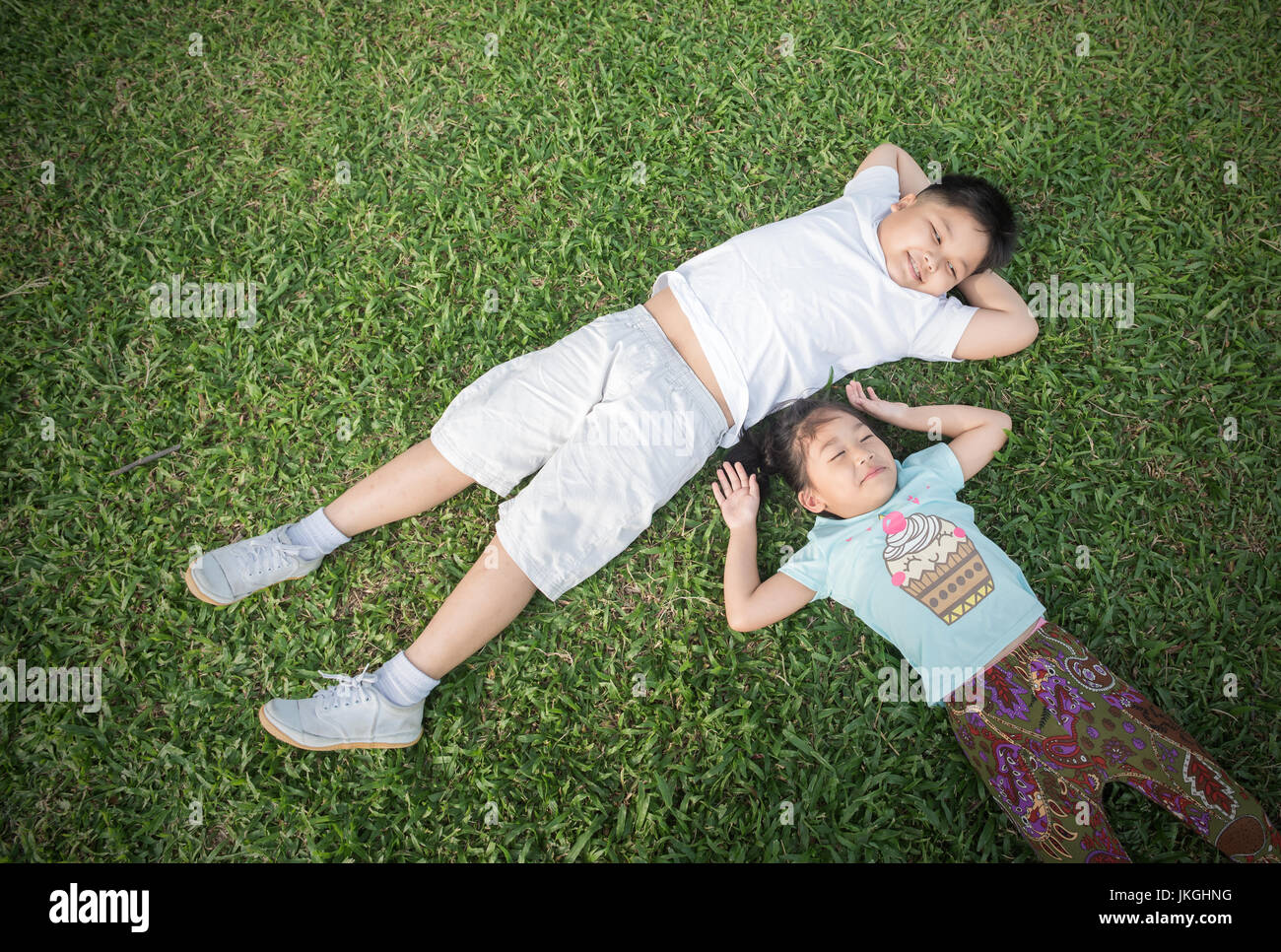 Smile children lie down on grass, concept recreation and liesure Stock ...