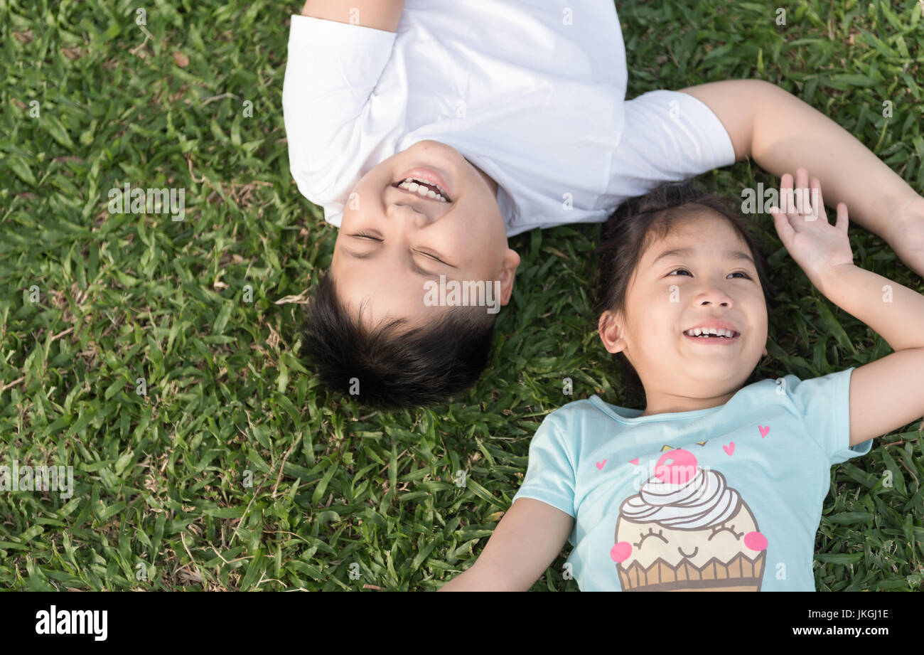 Smile children lie down on grass, concept recreation and leisure Stock ...