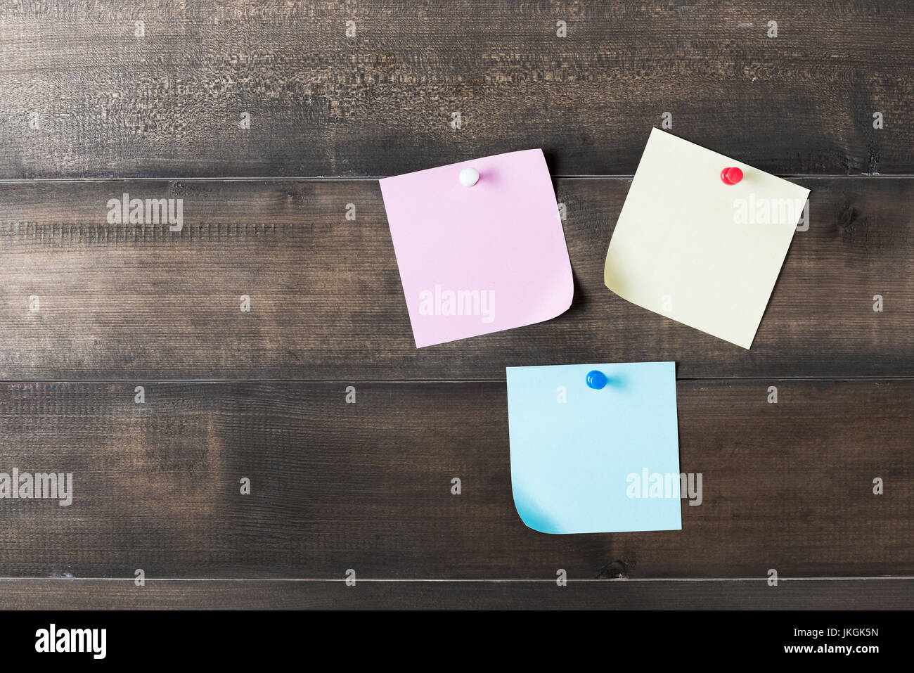 color paper note with pin on old wood background, concept remember and ...