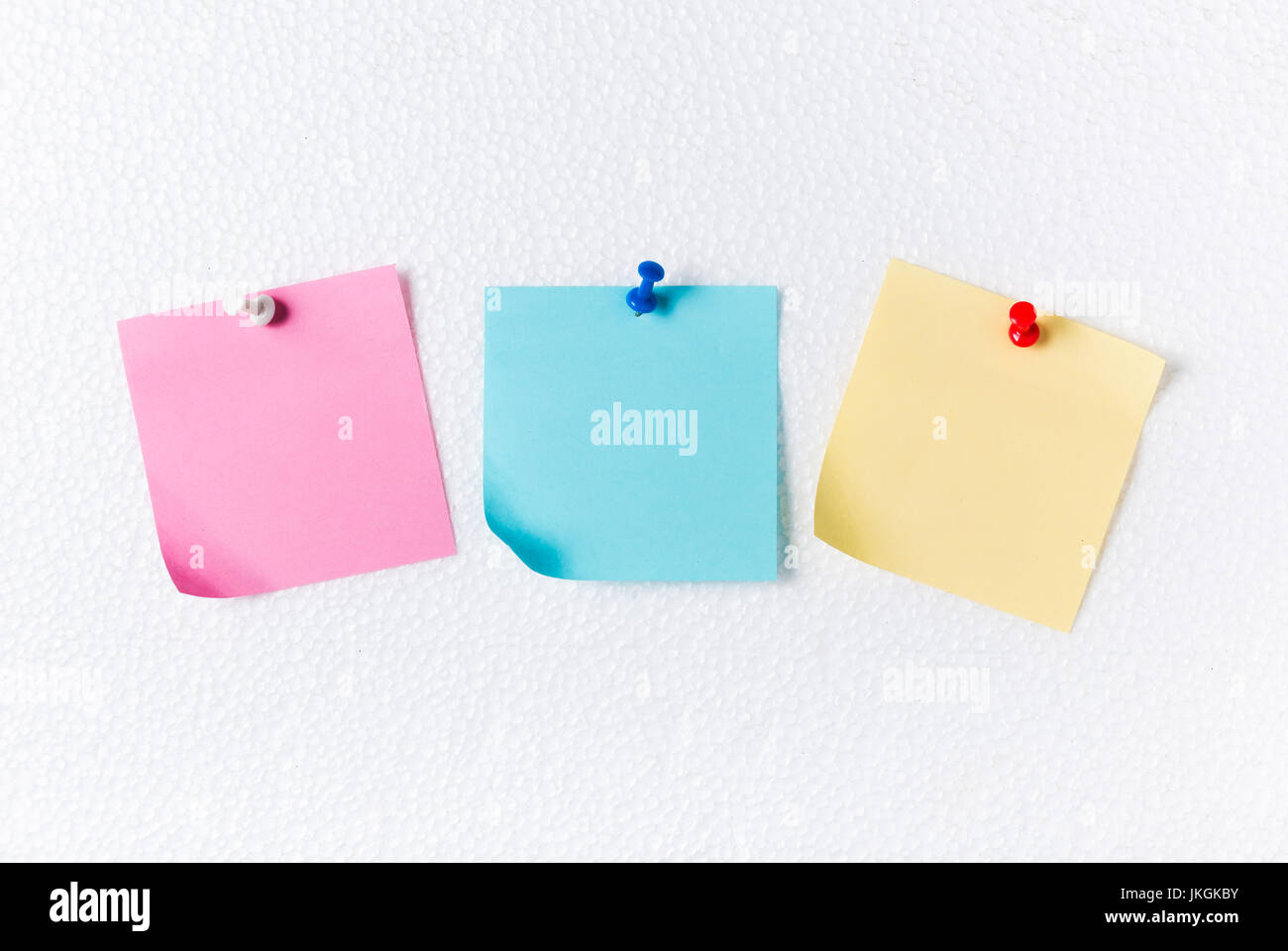 pink blue and yellow paper note with pin on foam sheet, concept ...