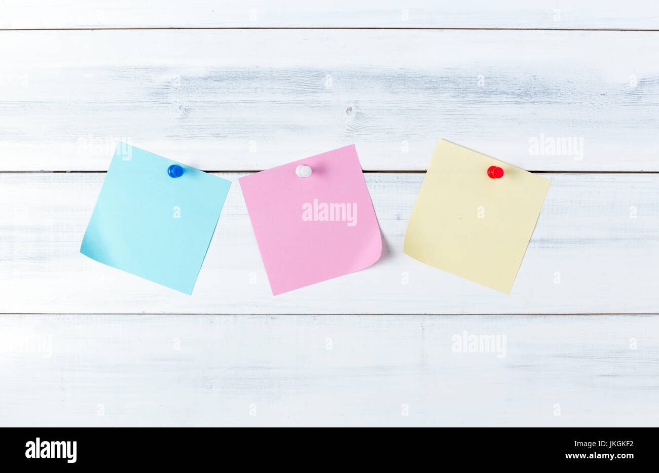 color paper note with pin on old wood background, concept remember and ...