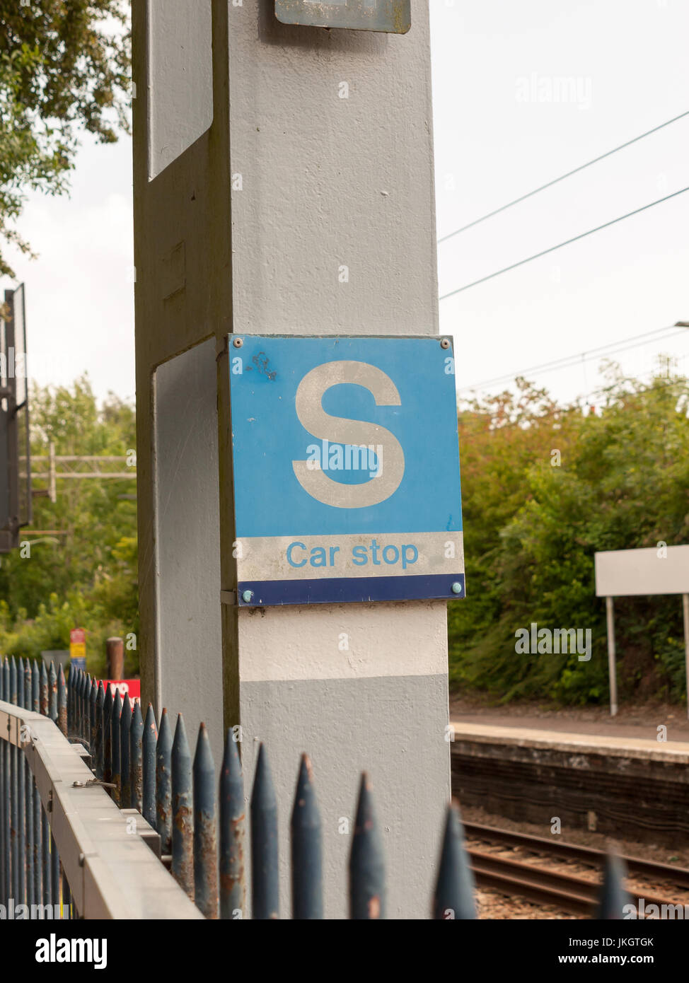 a blue car stop s sign at railway station on tracks; Essex; UK Stock ...