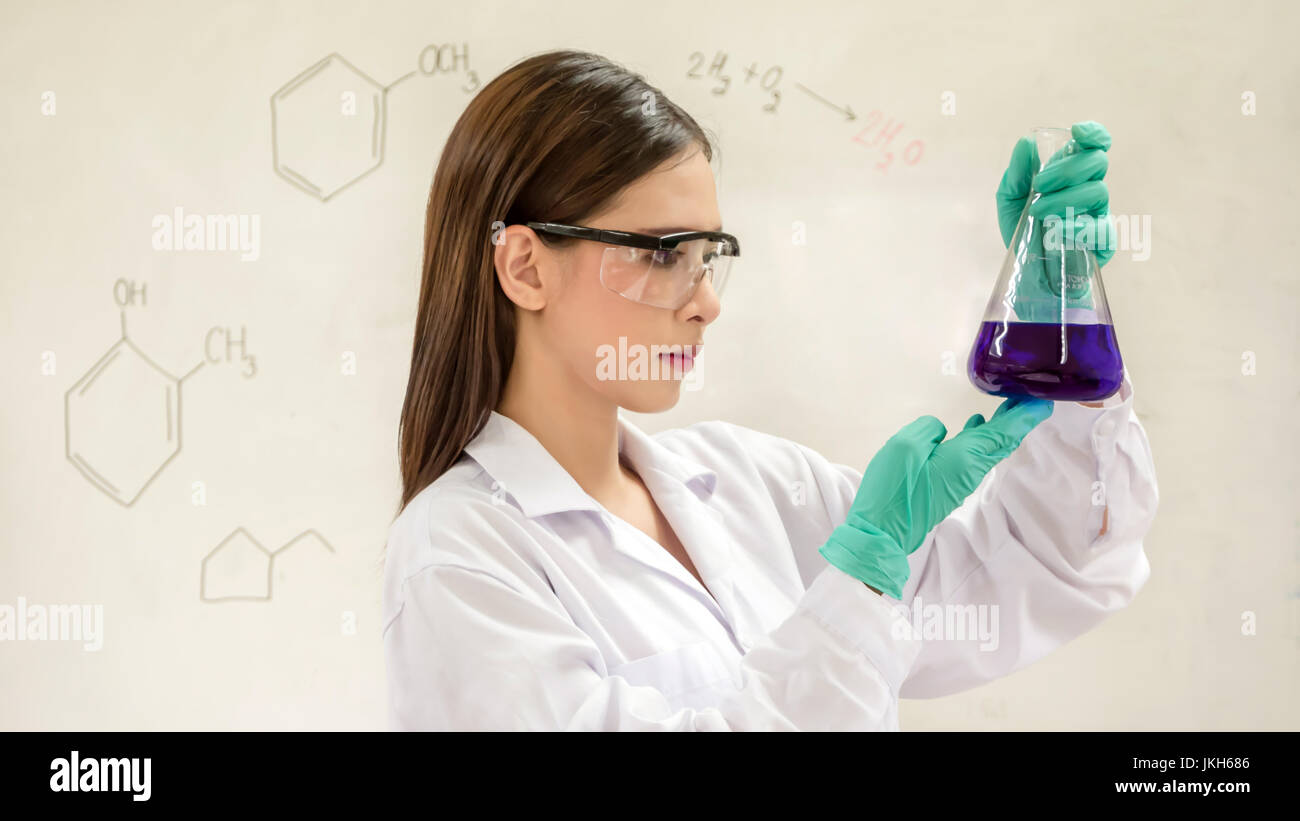 Portrait of Asian scientific researcher holding at a liquid solution in ...