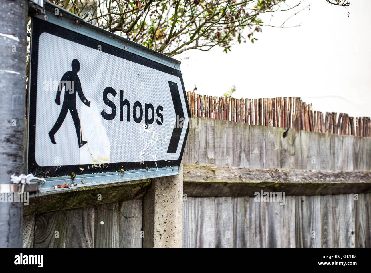 Public or Road Sign Directing People to the Shops Against a Wooden ...