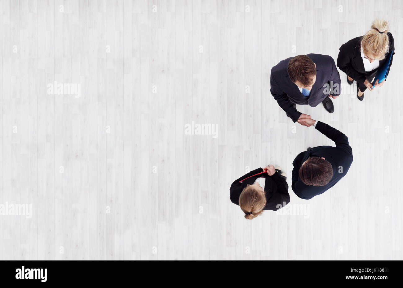 Business people shaking hands, finishing up a meeting, top view with ...