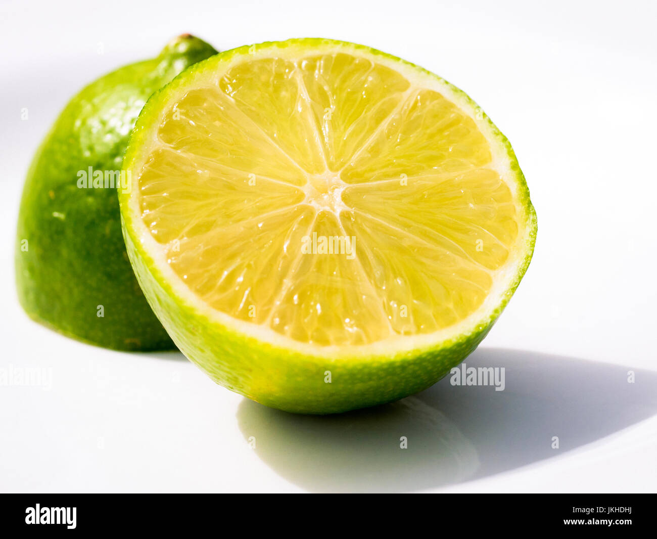 Two pieces of Lime cut in half Stock Photo - Alamy