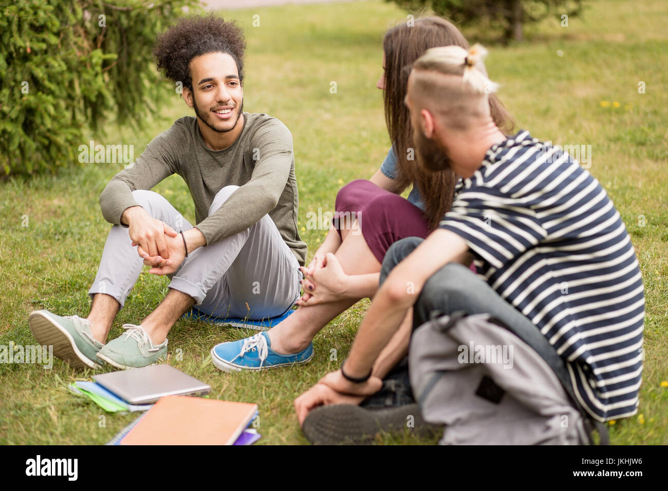 Students sitting at lawn talking after classes Stock Photo - Alamy