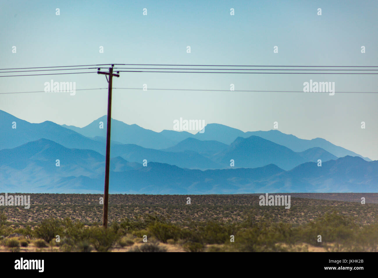 A set of wires and a pole are in front of layered mountains in Utah ...