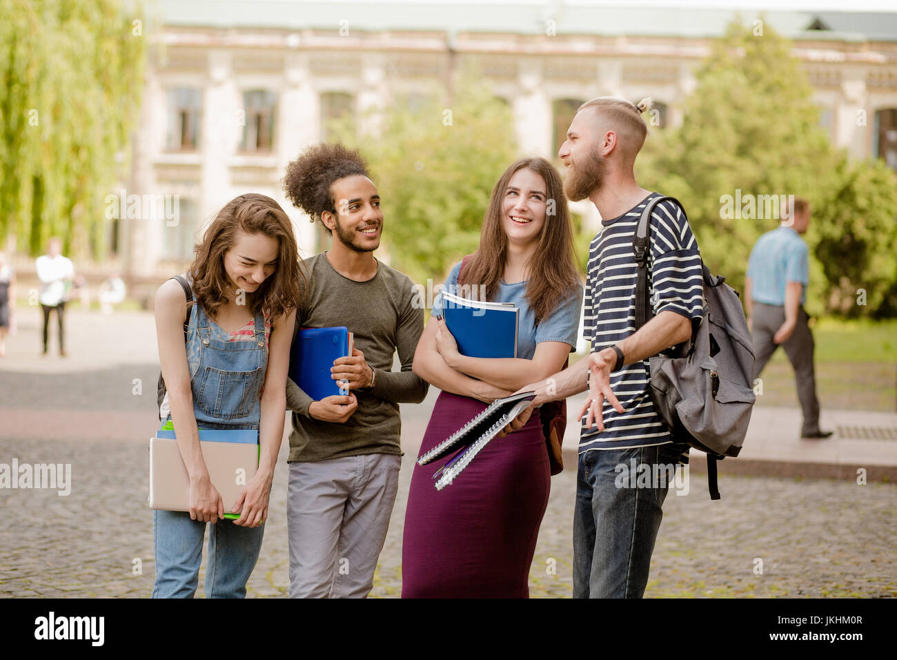 College friends standing, laughing in campus Stock Photo - Alamy