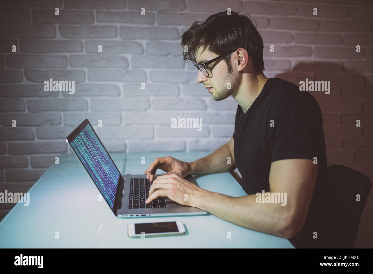 Young man programer work on laptop in the night and hack the network ...