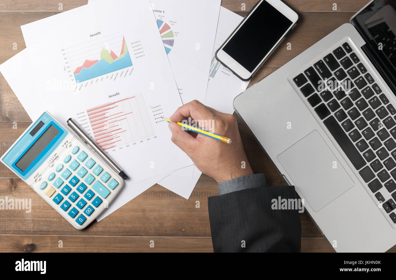 Unrecognizable business person analyzing graphs and taking notes Stock ...