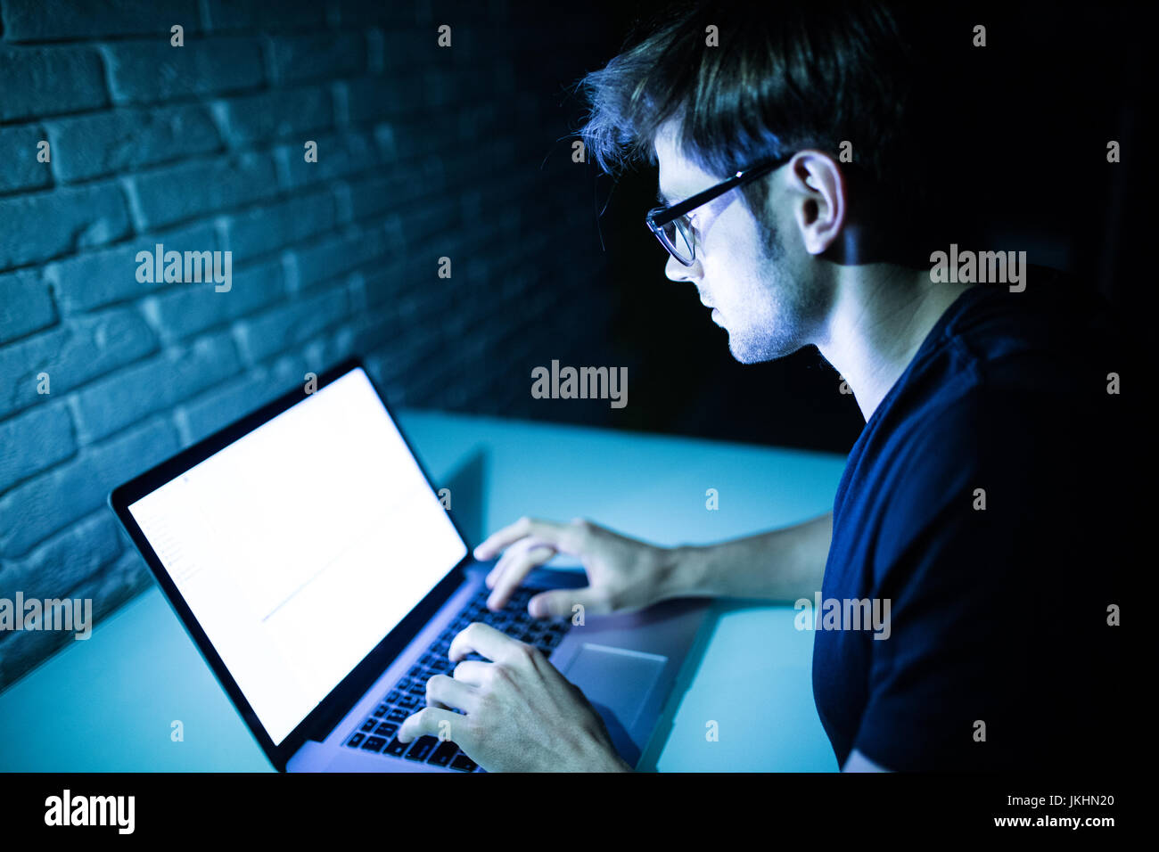 Man using laptop in the night with white screen Stock Photo - Alamy