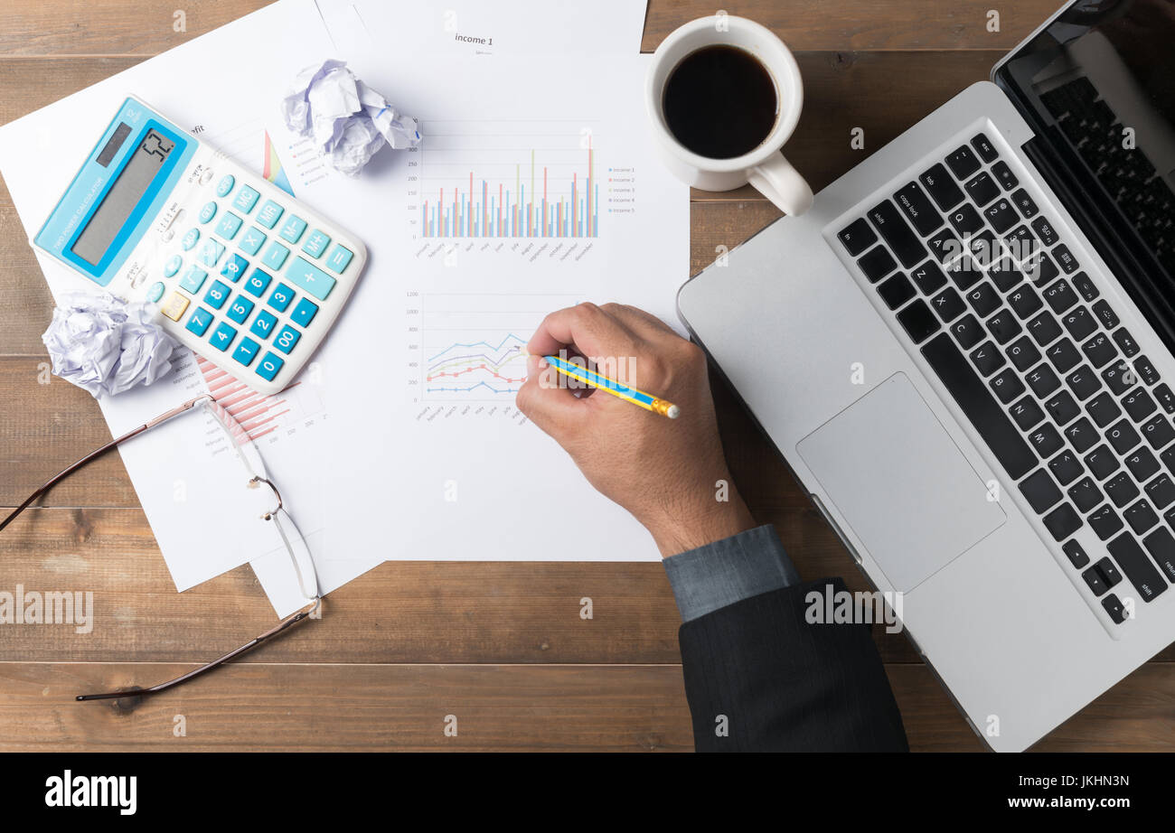 Unrecognizable business person analyzing graphs and taking notes Stock ...
