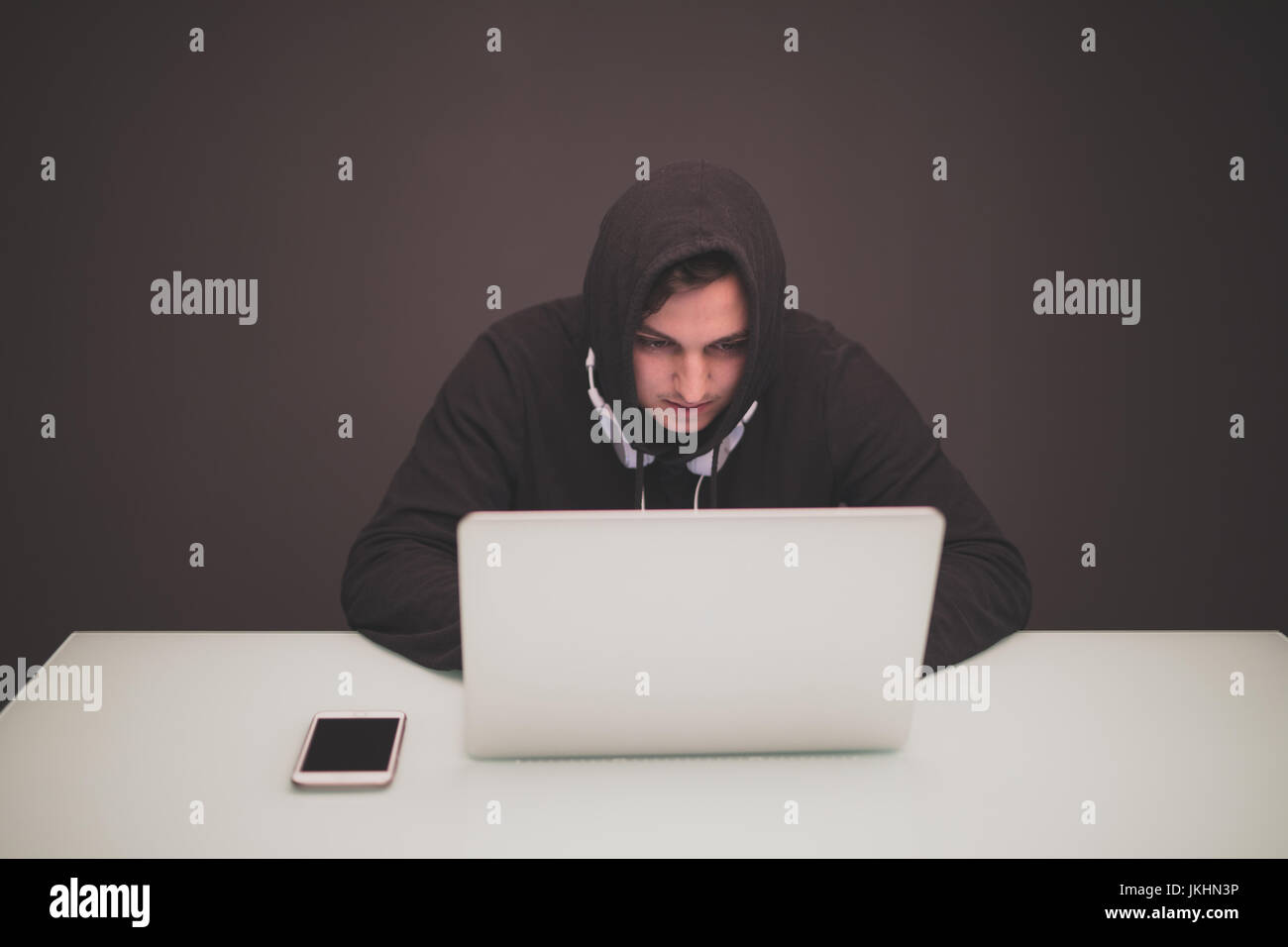 Computer criminal or hacker sitting at a desk in the darkness stealing ...