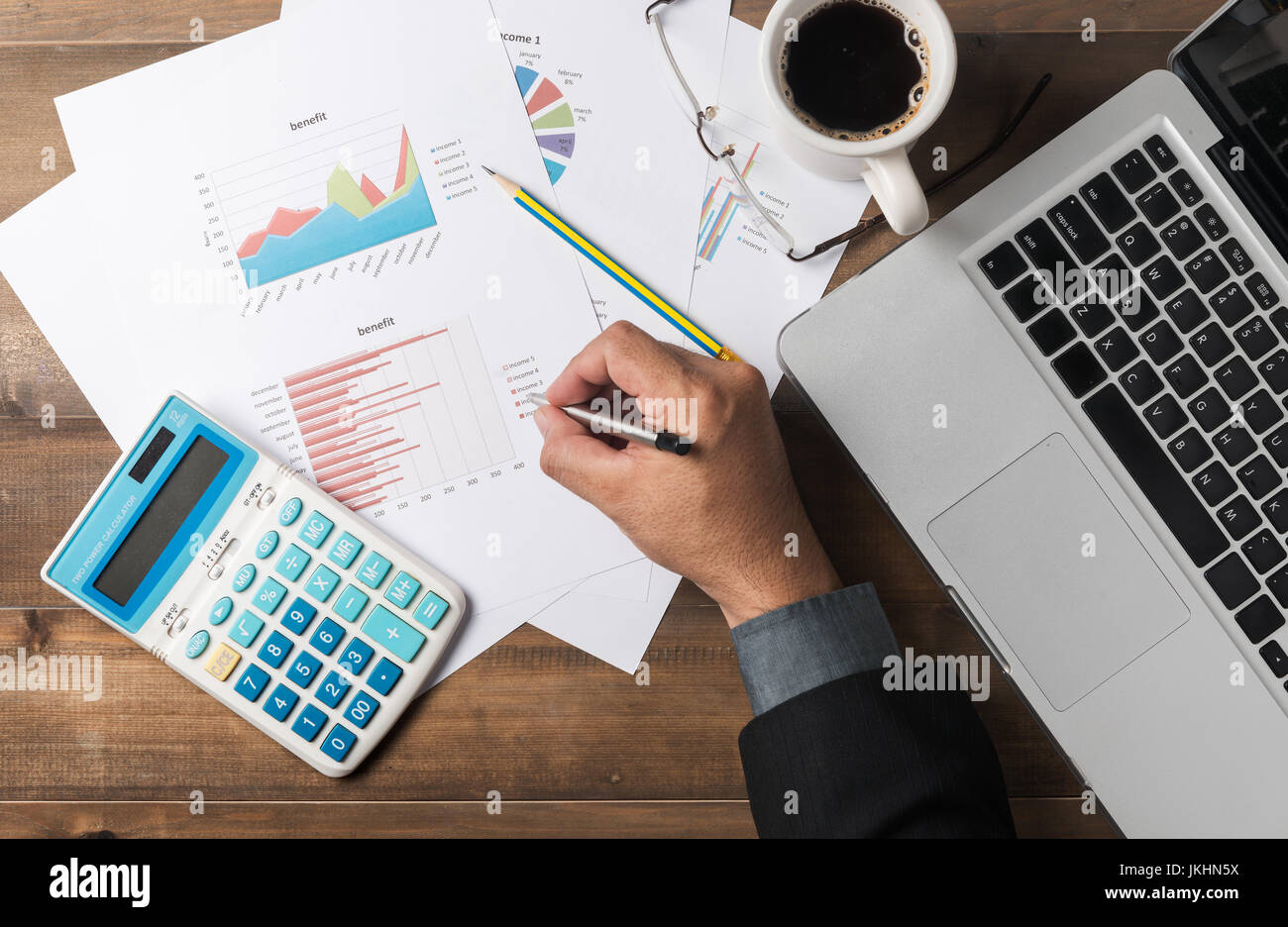 Unrecognizable business person analyzing graphs and taking notes Stock ...