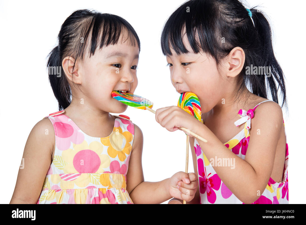Asian Little Chinese girls eating lollipop in isolated white background ...