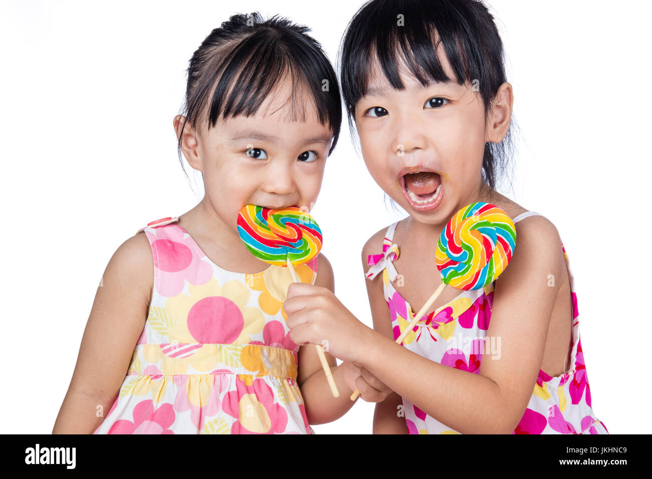 Asian Little Chinese girls eating lollipop in isolated white background ...