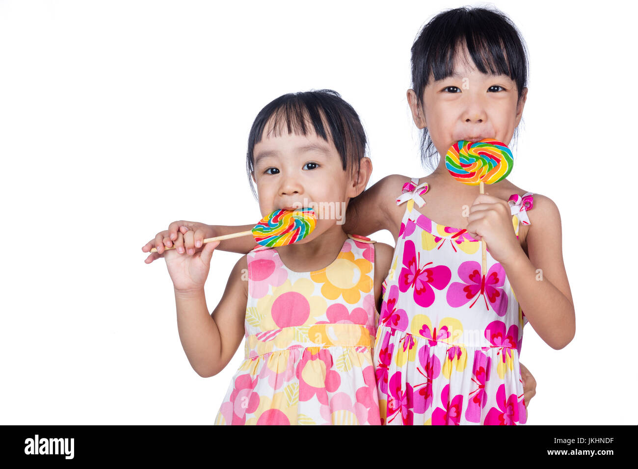 Asian Little Chinese girls eating lollipop in isolated white background ...