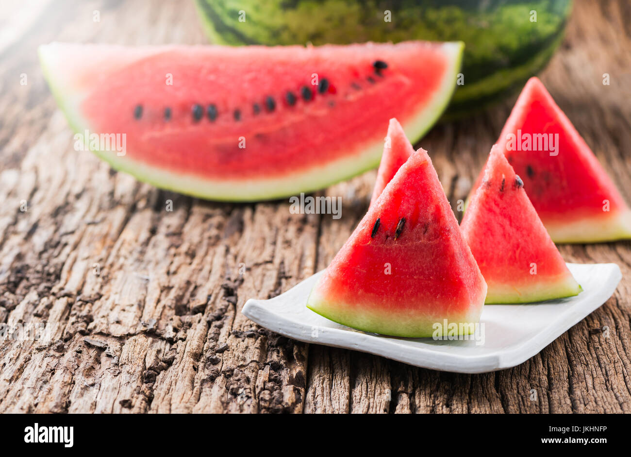 red slice watermelon on white dish and old wood background Stock Photo ...
