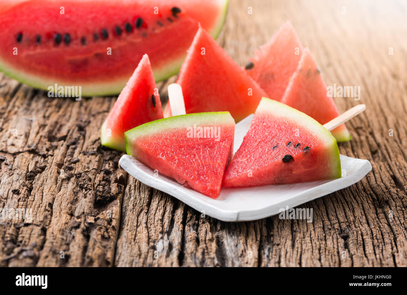 red slice watermelon on white dish and old wood background Stock Photo ...