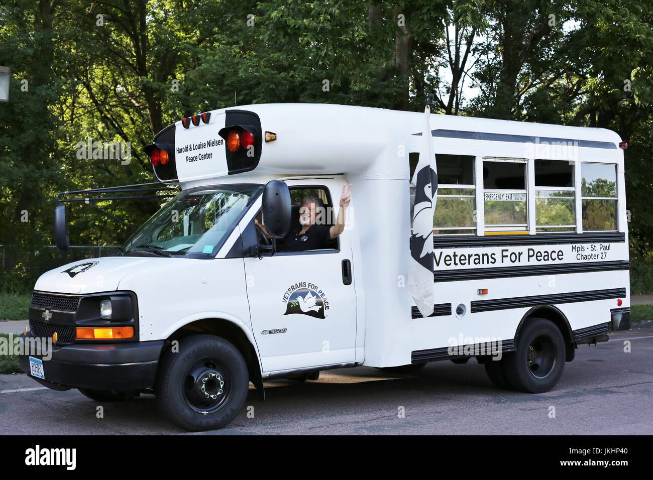 A man driving a Veterans for Peace bus and giving a peace sign out the ...