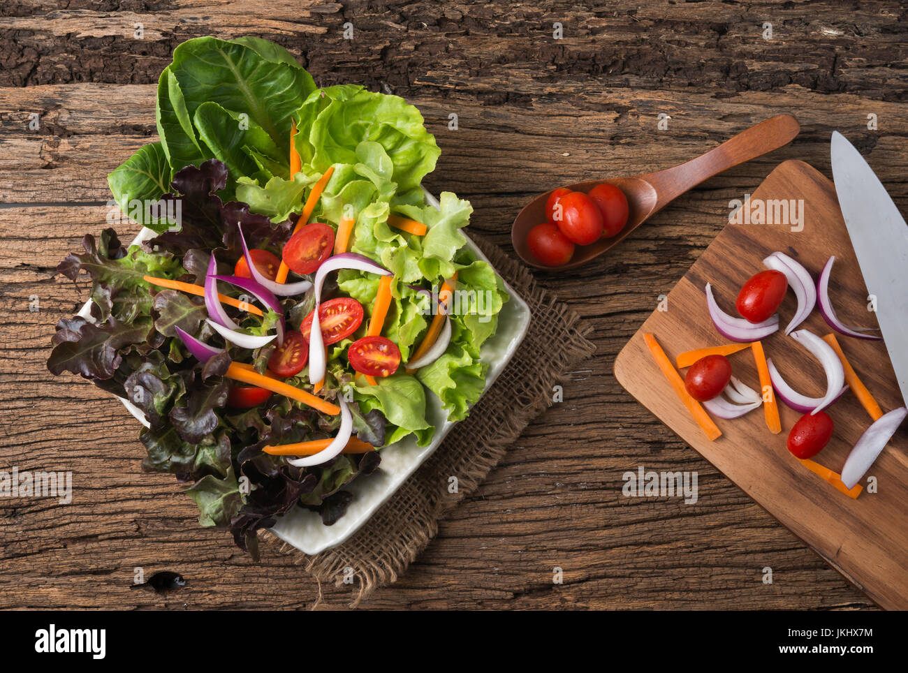 Red Oak and Green Oak salad and fresh vegetables on wood background ...