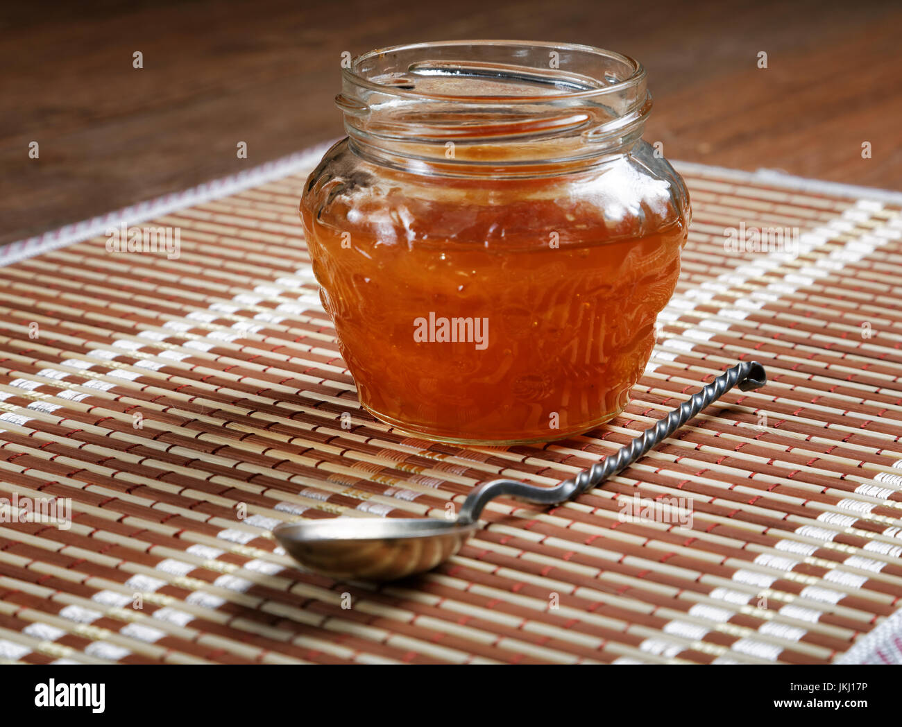Jam jar with a spoon on a close-up table Stock Photo - Alamy