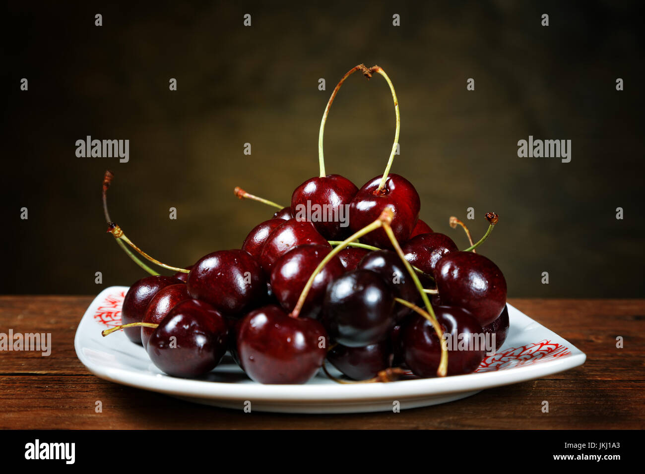 Cherry in a plate on a rural table Stock Photo - Alamy