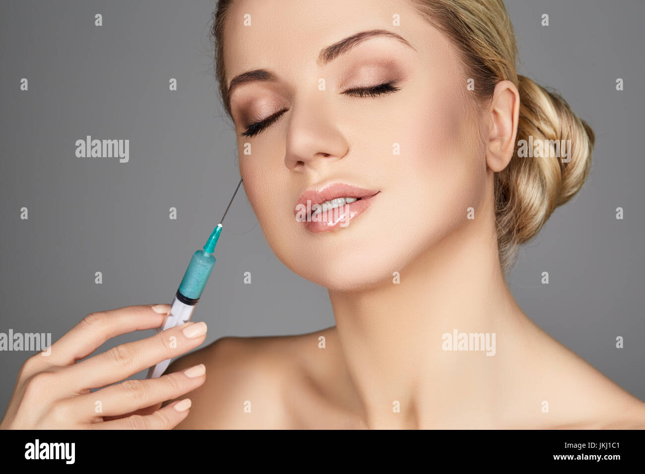 beautiful happy young woman holding syringe with collagen treatment ...