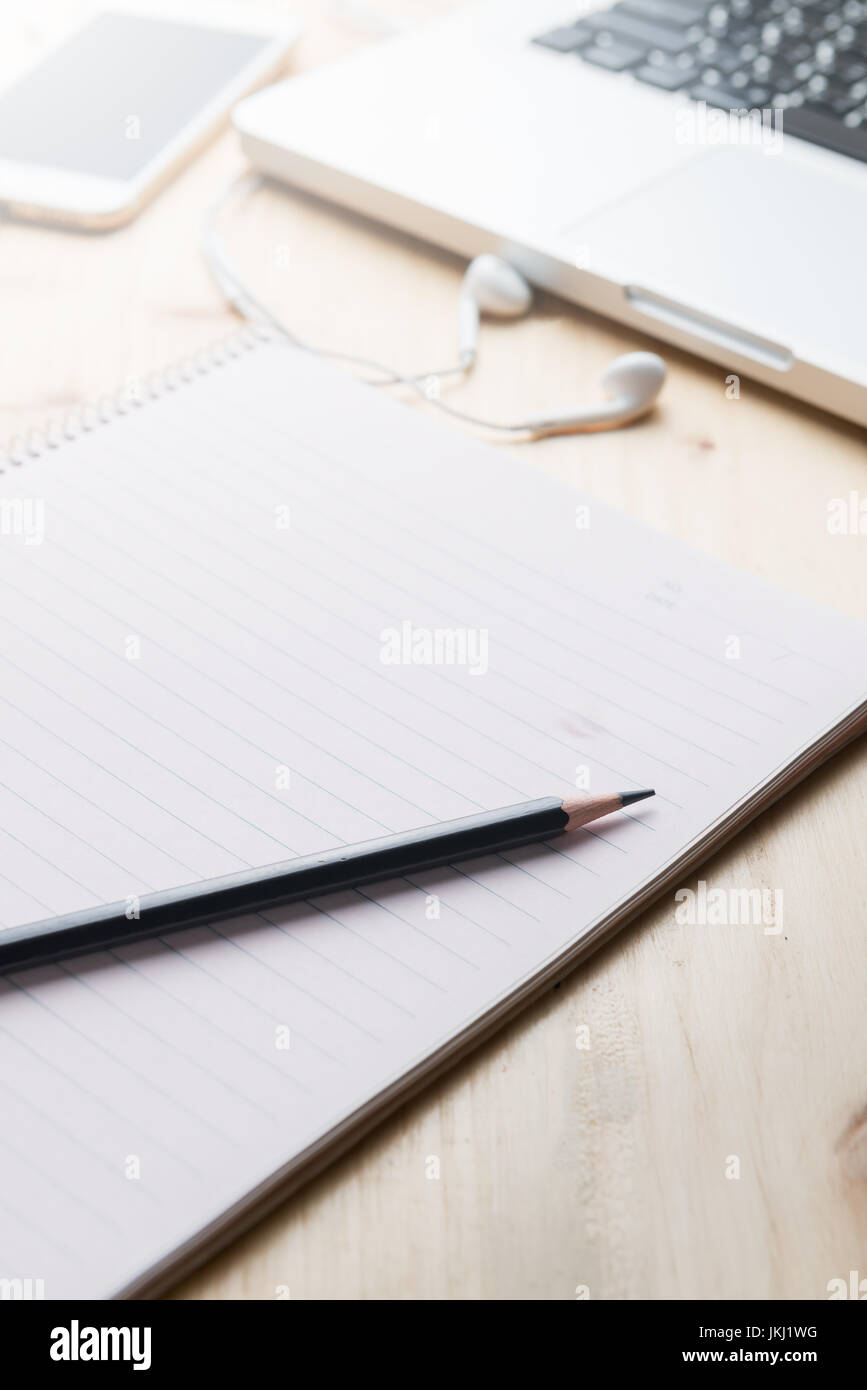 black pencil on blank notebook and laptop on wood background Stock ...