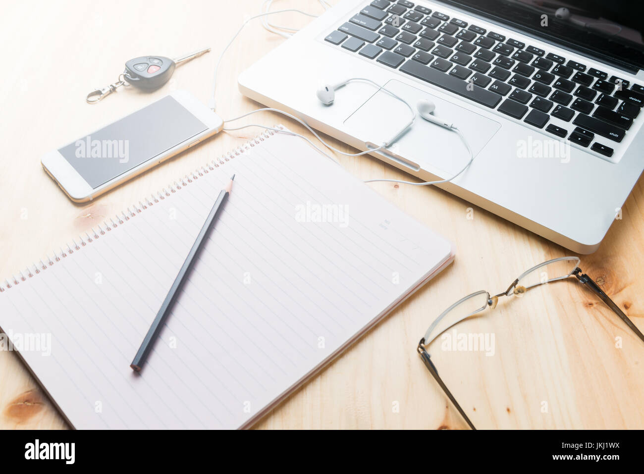 black pencil on blank notebook and laptop on wood background Stock ...