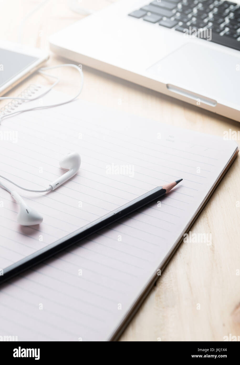 black pencil on blank notebook and laptop on wood background Stock ...