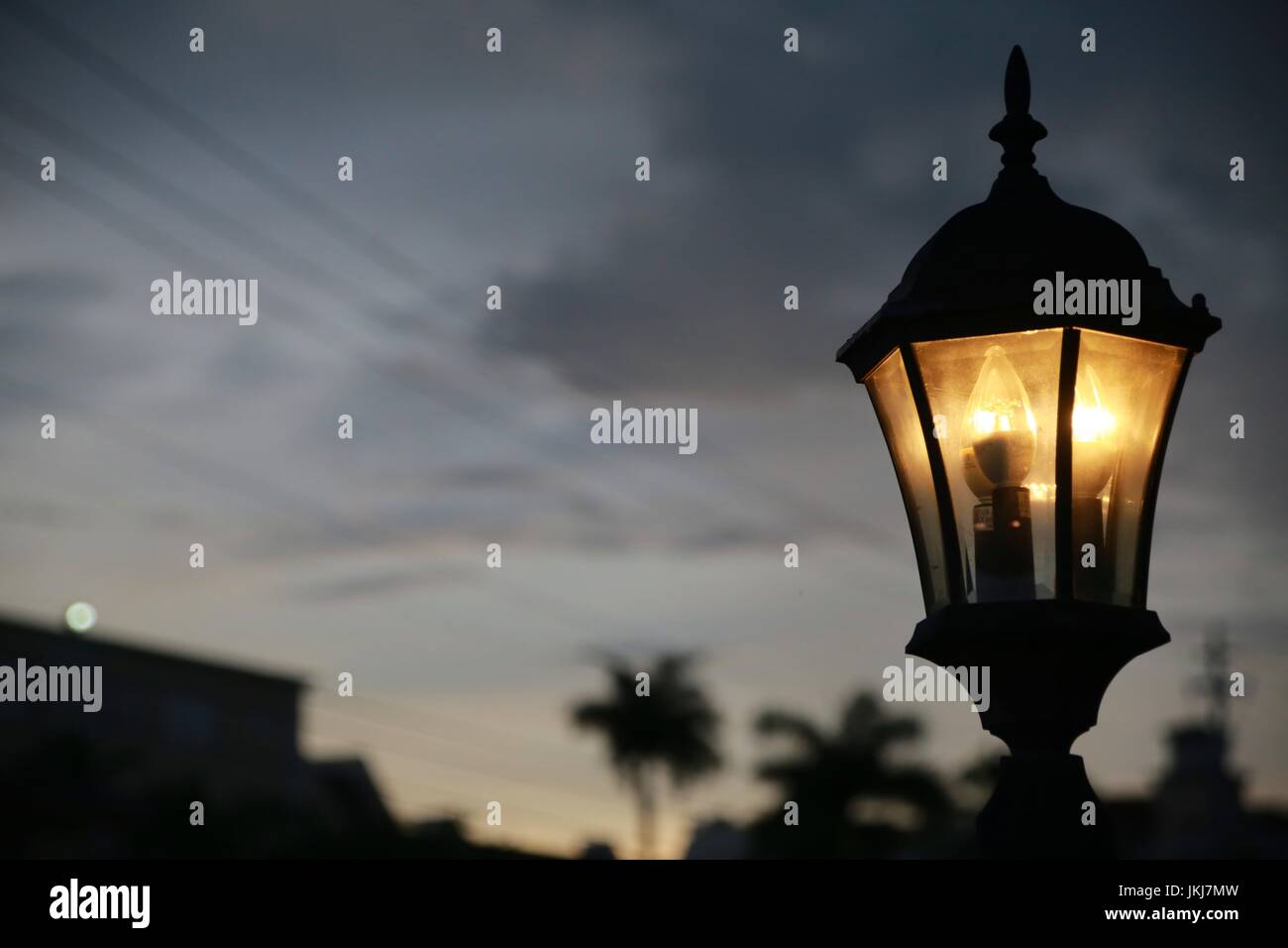 Street Light in Front of Car Approaching with Headlights Illuminated at ...
