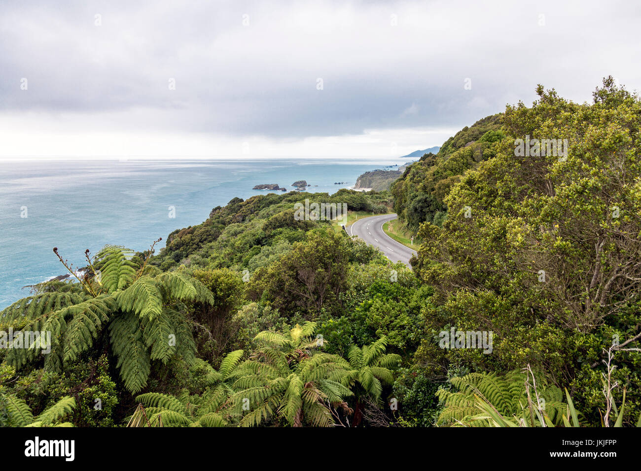 Road though lush, green scenery on the West Coast of the South Island ...