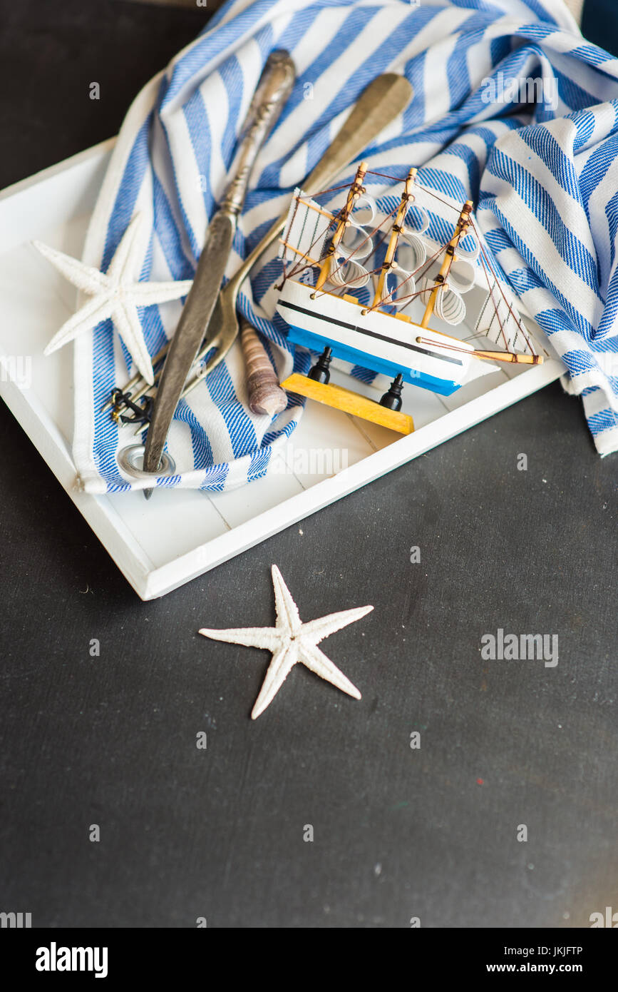 Summer marine themed table setting with stripped napkin and seashells ...