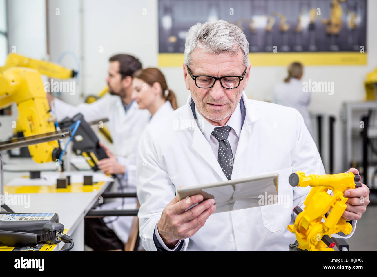 Engineer holding tablet and model of an industrial robot Stock Photo ...