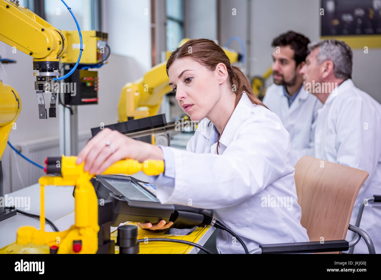 Engineers examining industrial robots Stock Photo - Alamy