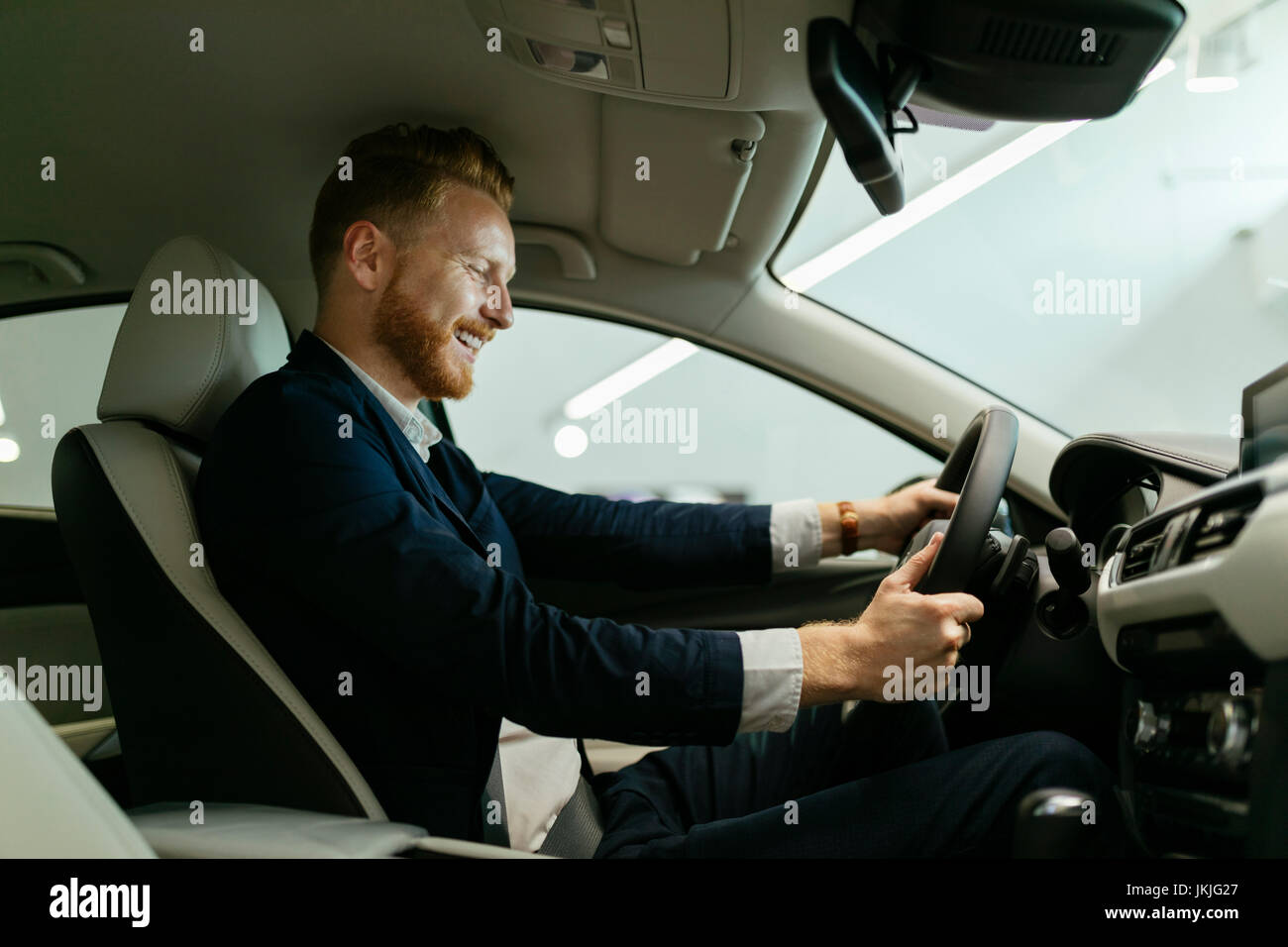 Businessman testing car in car dealership Stock Photo - Alamy