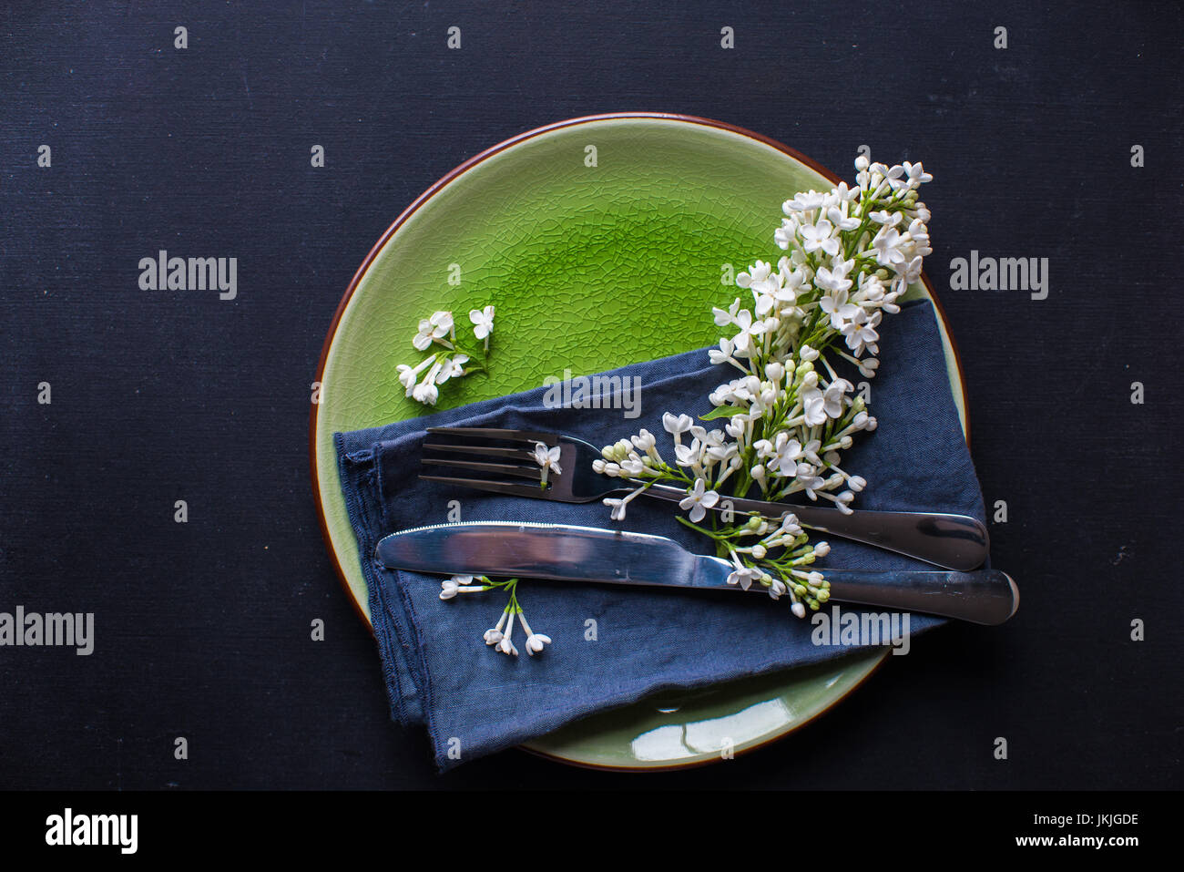 Pring Table Setting With White Lilac Flowers On The Plate With Flatware On Rustic Wooden Table