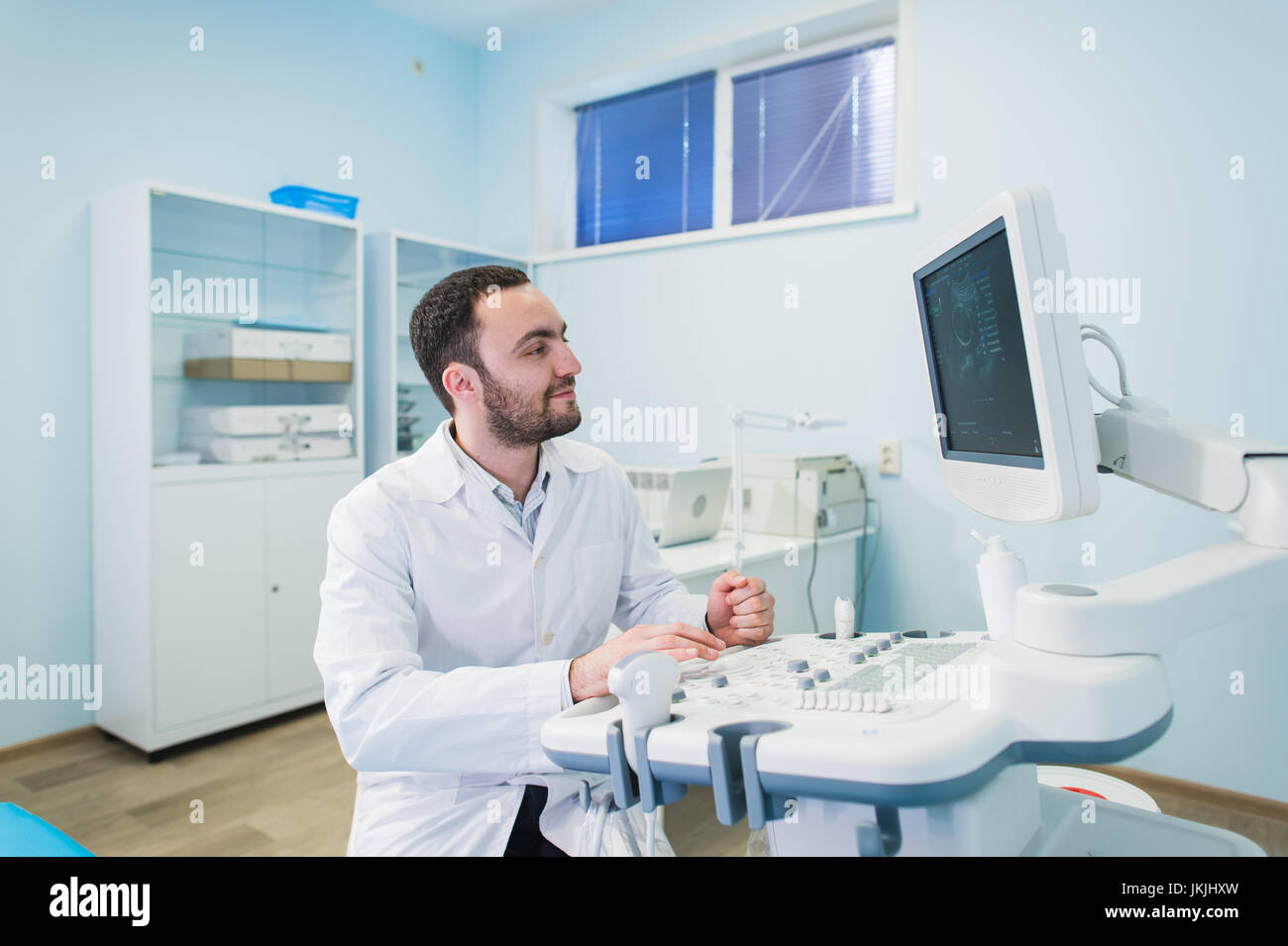 Male doctor with ultrasonic equipment during ultrasound medical ...