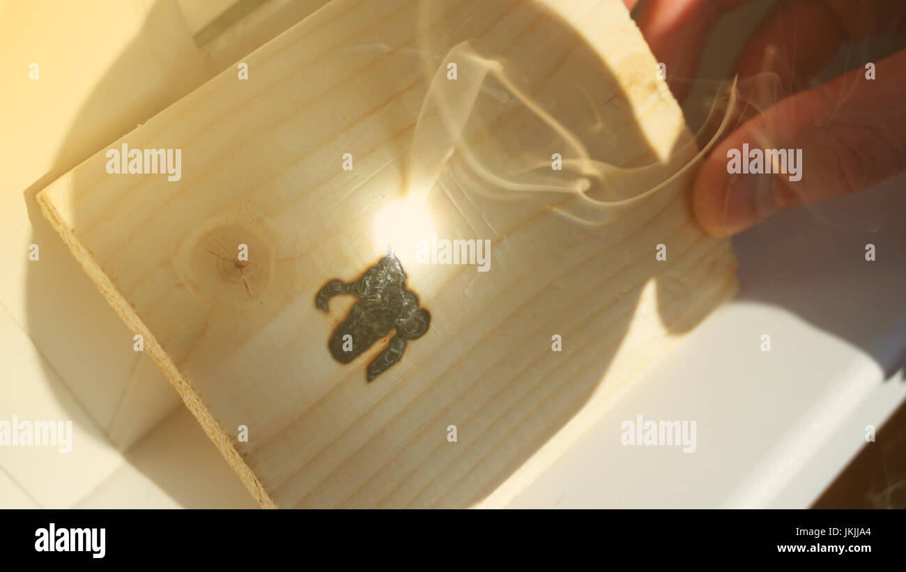 Sunlight focused by a converging magnifying glass can burn wooden bar ...