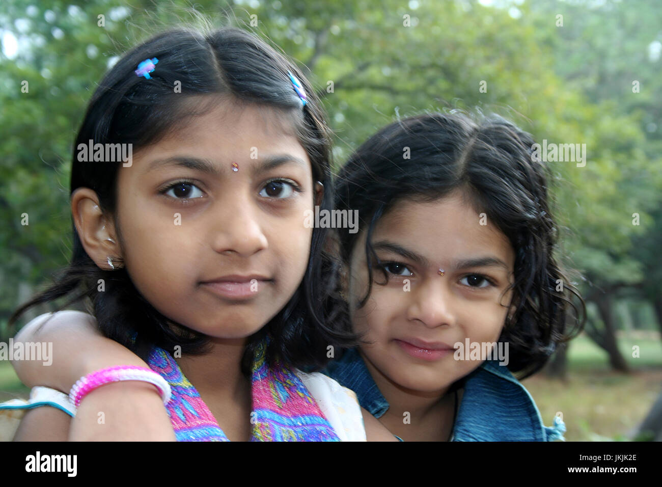 Younger sister affectionately putting her arm over the shoulder of her ...