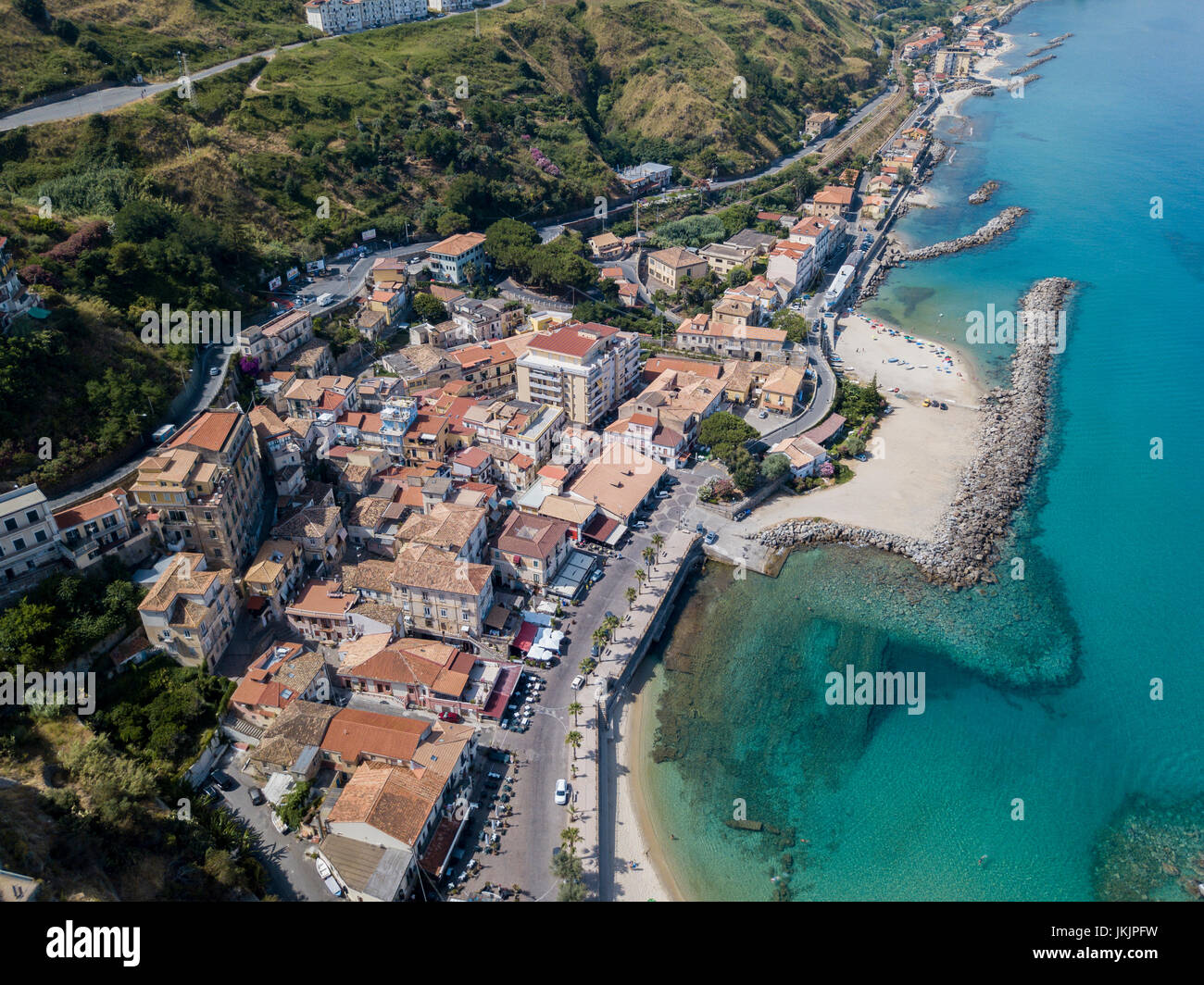 Aerial view of a beach and a pier with canoes, boats and umbrellas ...