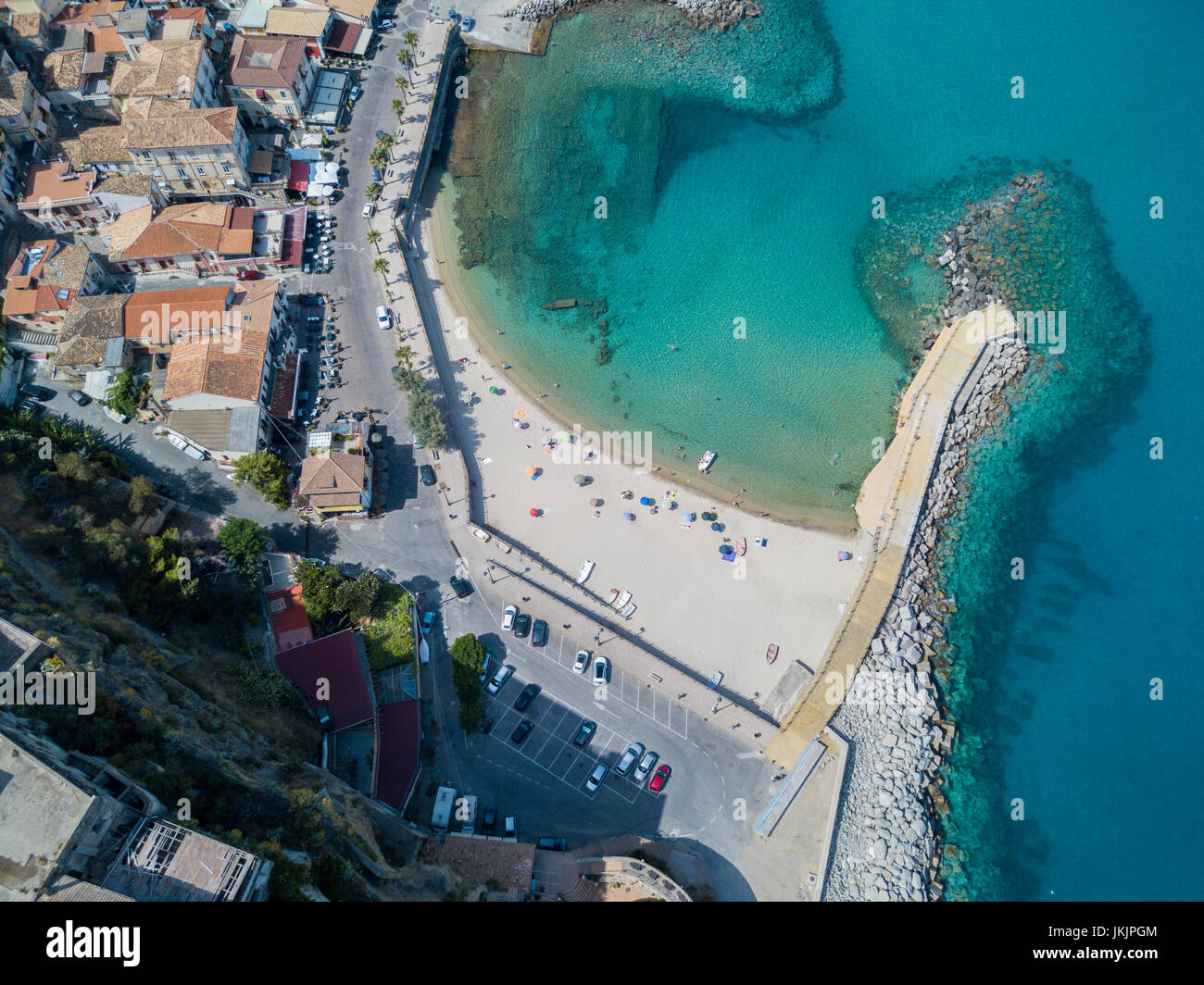 Aerial view of a beach and a pier with canoes, boats and umbrellas ...