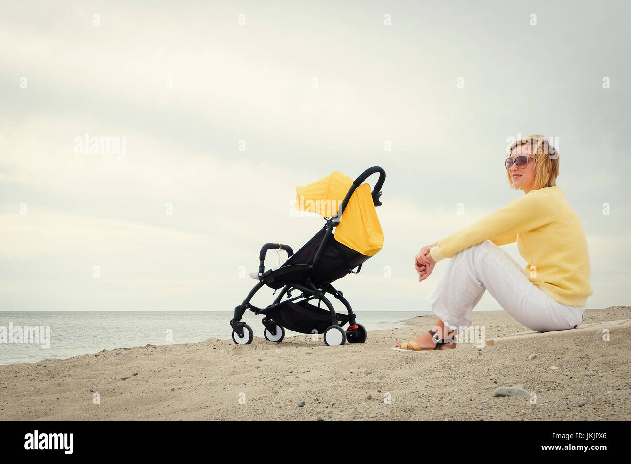 Mother gets some rest on beach Stock Photo - Alamy