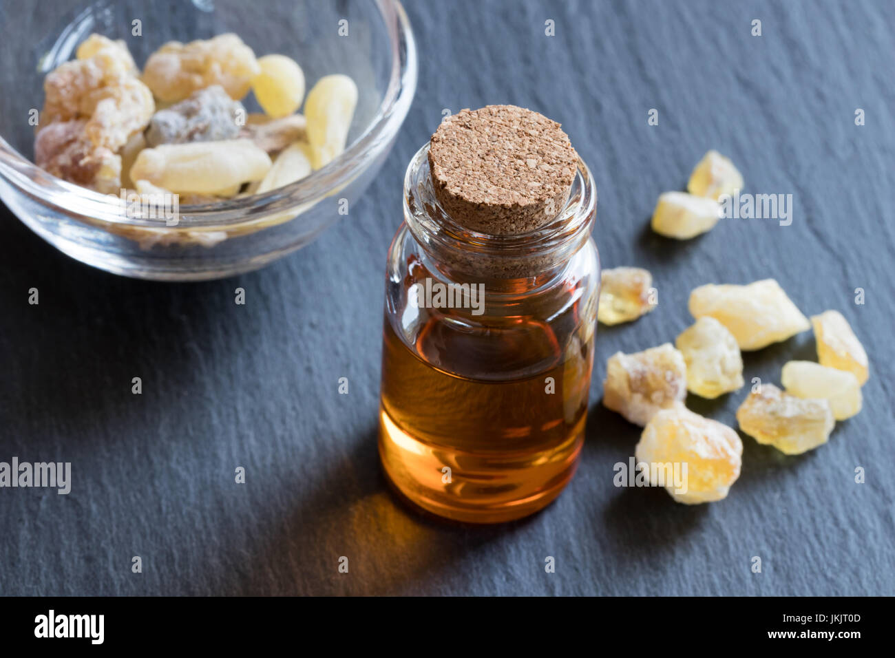 A bottle of frankincense essential oil with frankincense resin crystals ...