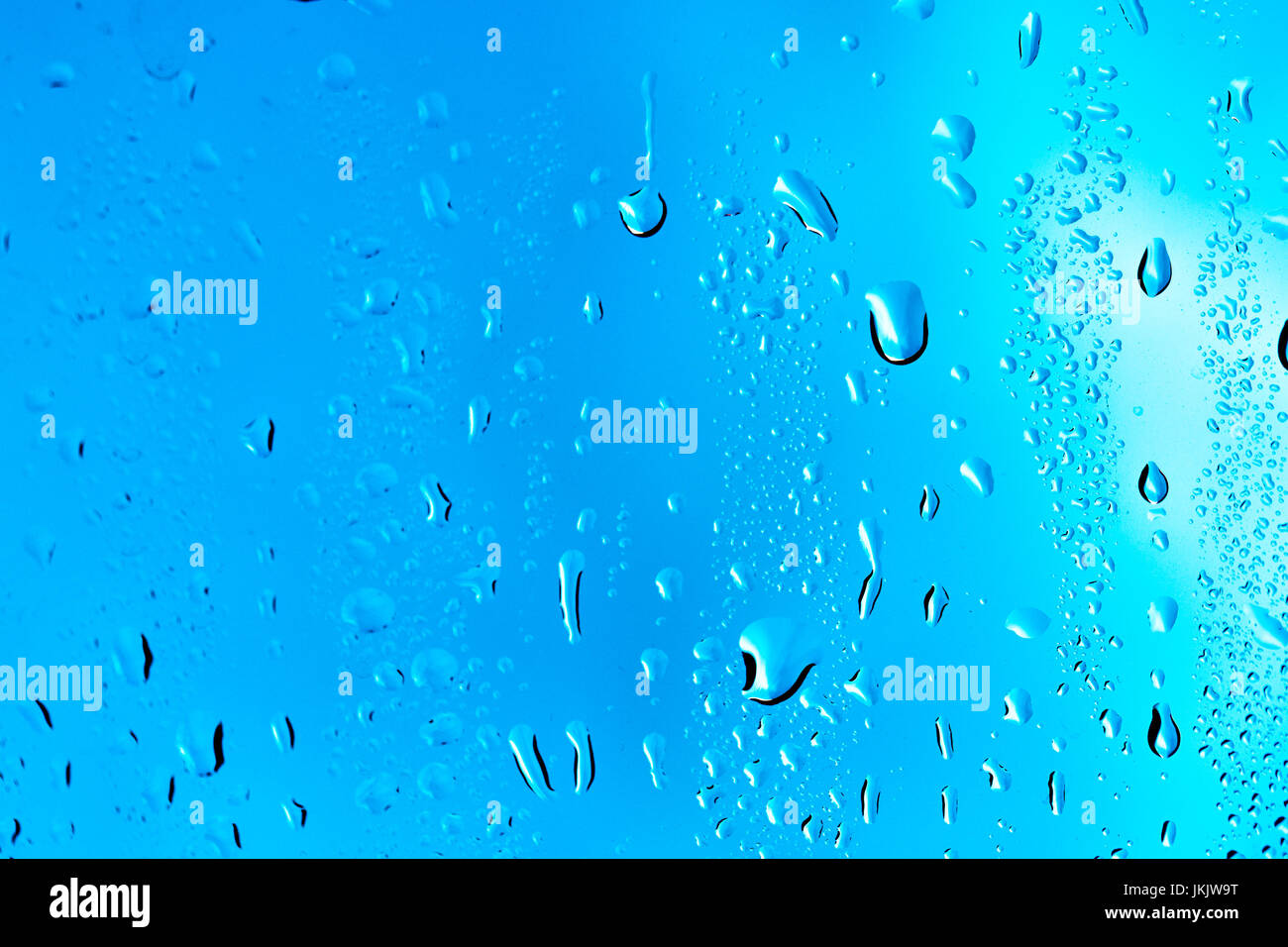 Drops on the glass rain blue background Stock Photo - Alamy